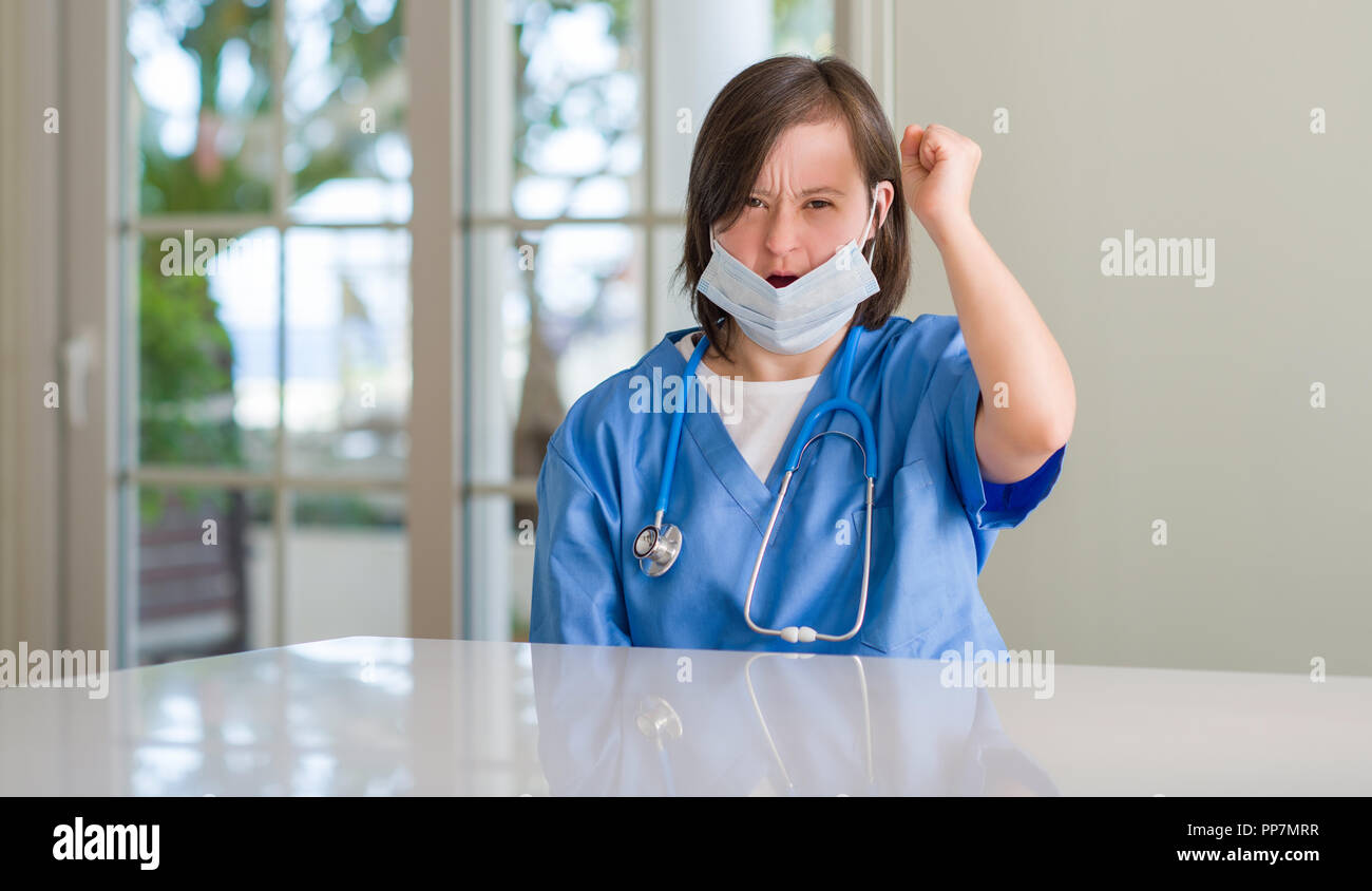 Down syndrome woman wearing nurse uniform annoyed and frustrated ...
