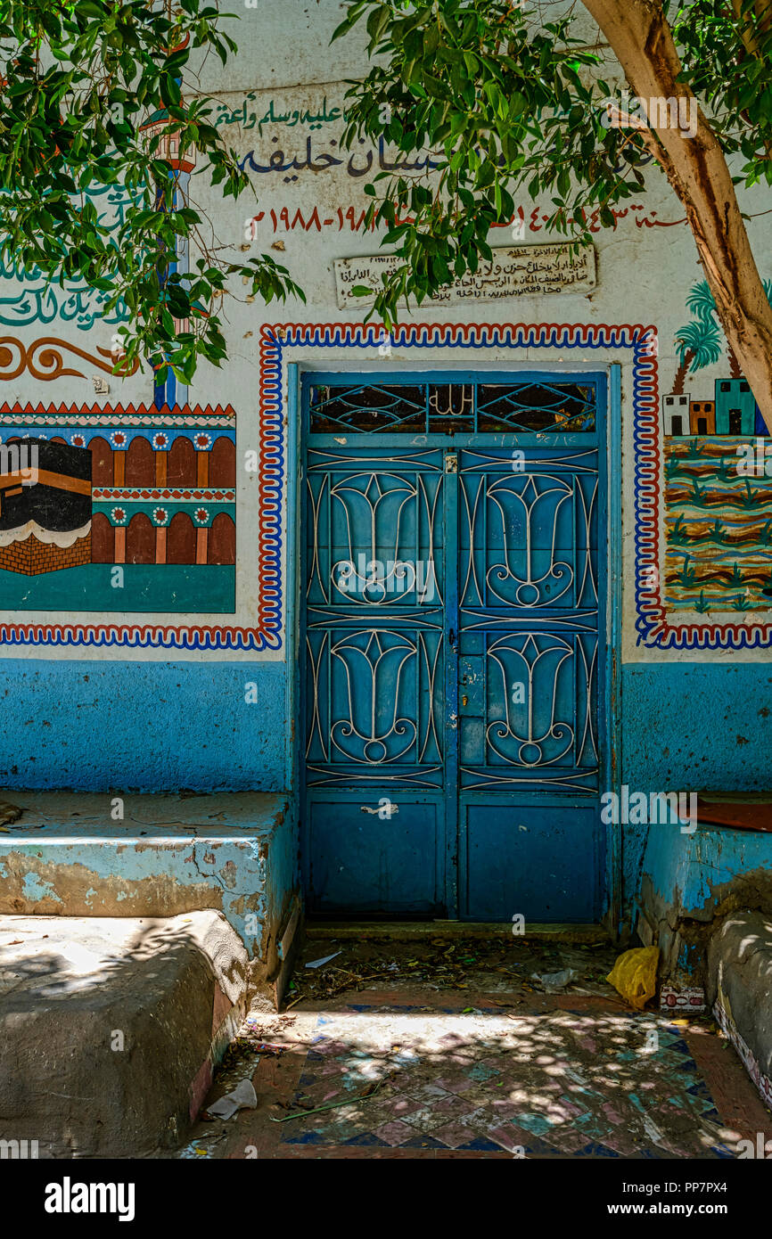 Door and façade, with Arabic writings on the walls, of a village house ...