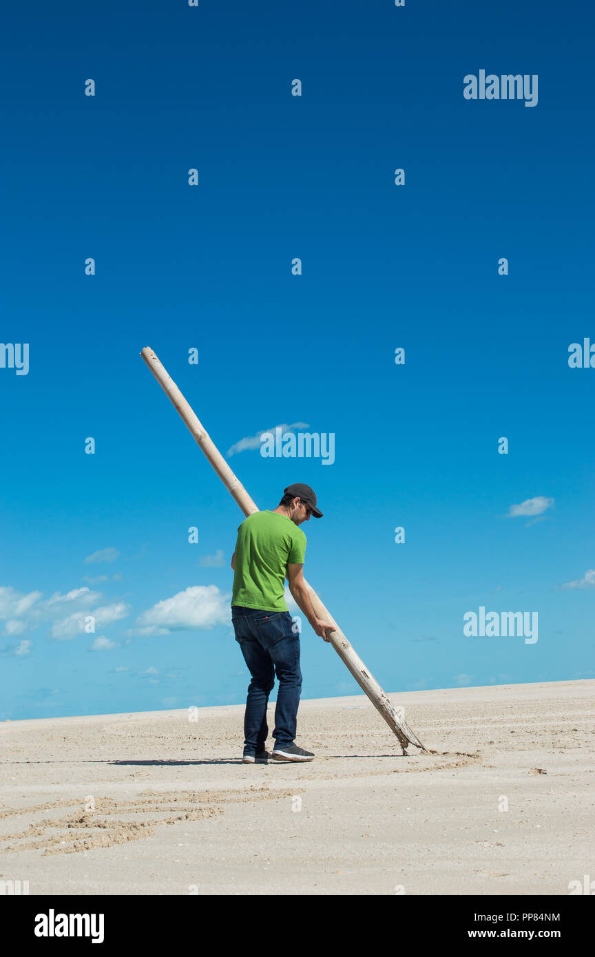 Man writing on sand with a large stick on a beach in Yucatan, Mexico ...