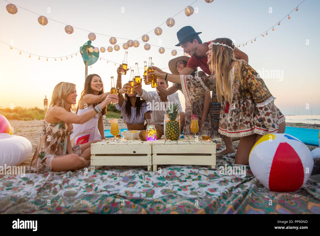 Group of friends having a picnic at the beach - Happy young people on a ...