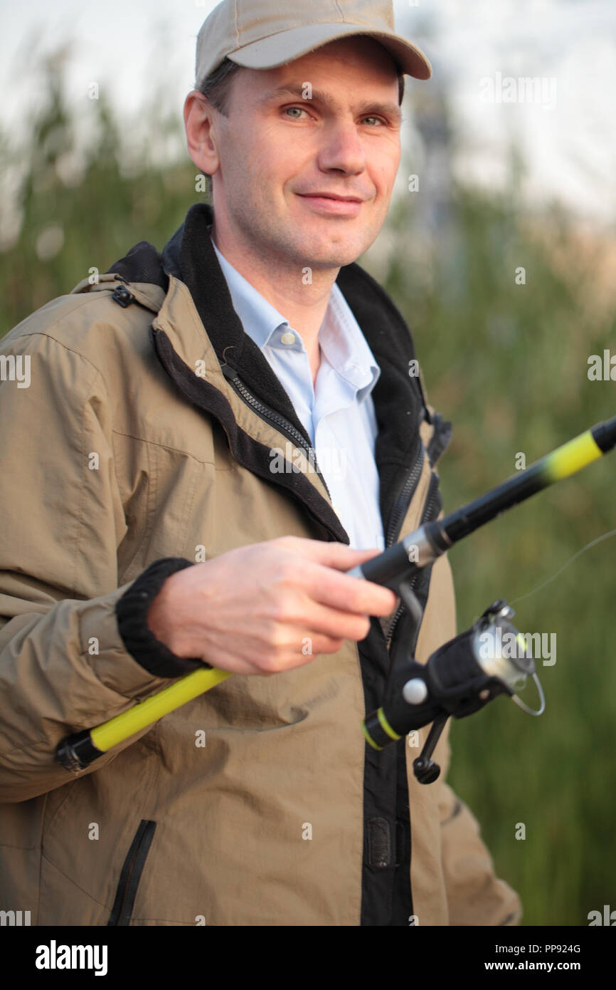 Fisherman with fishing rod Stock Photo - Alamy