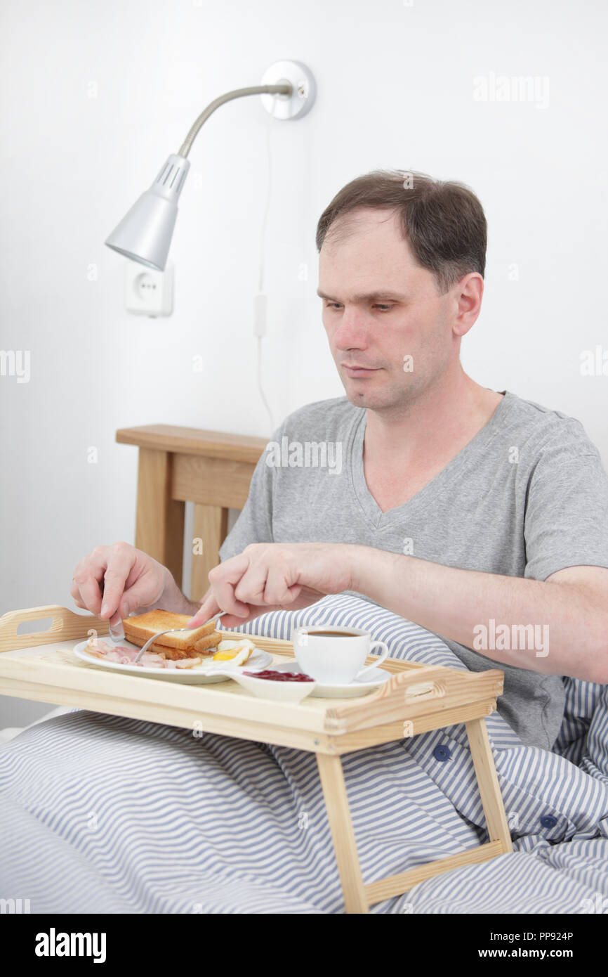 Man eating breakfast on the bed Stock Photo - Alamy