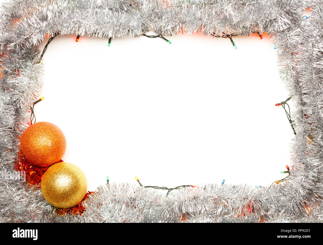 Christmas baubles with lights and silver tinsel frame on white ...
