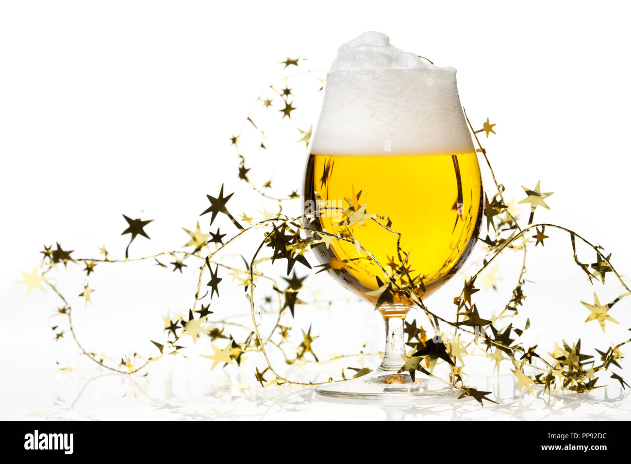 Full snifter glass of pale lager of pilsner beer with a large head of ...