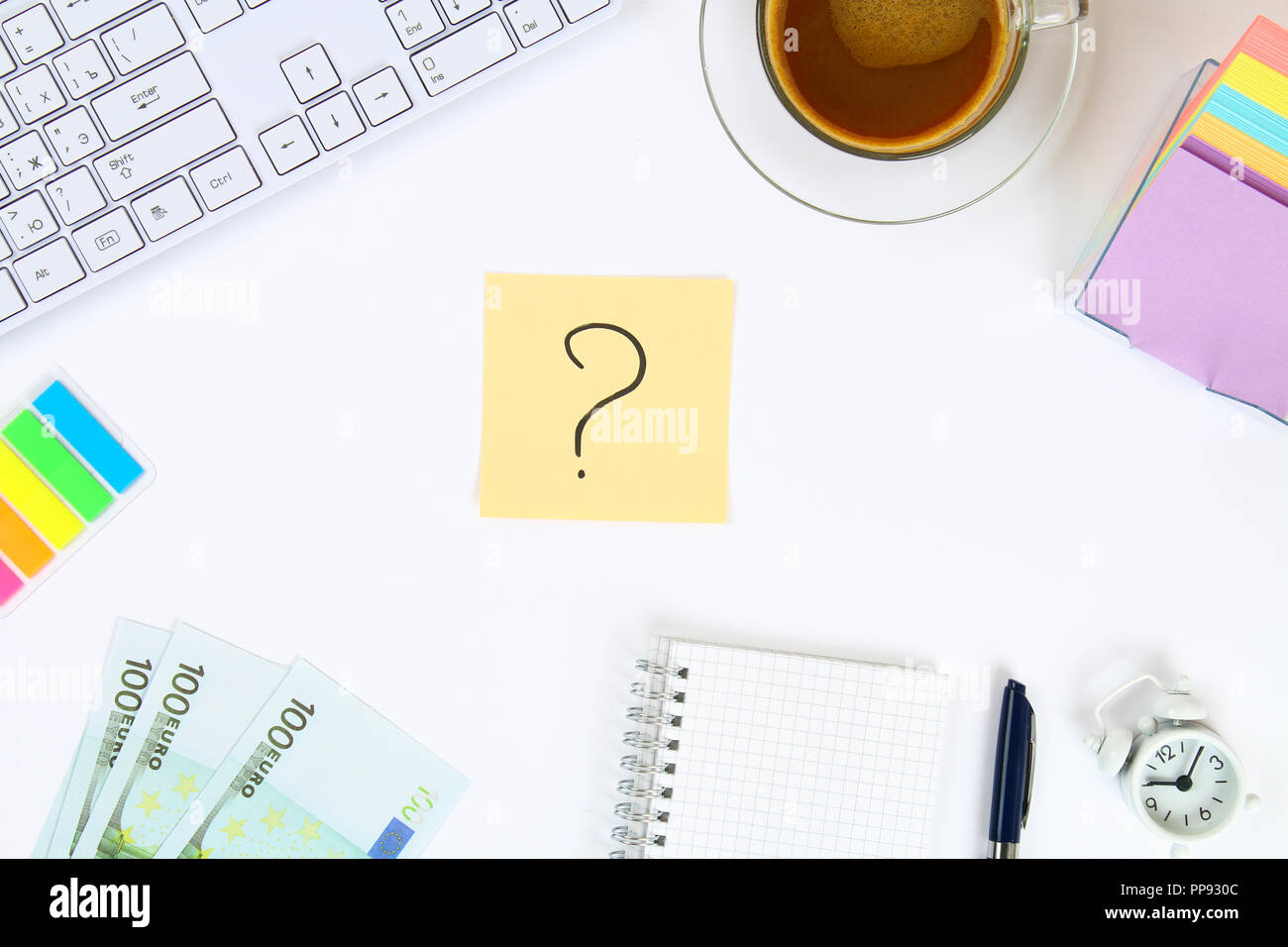 Multicolored stickers note with question mark on white desktop next to ...