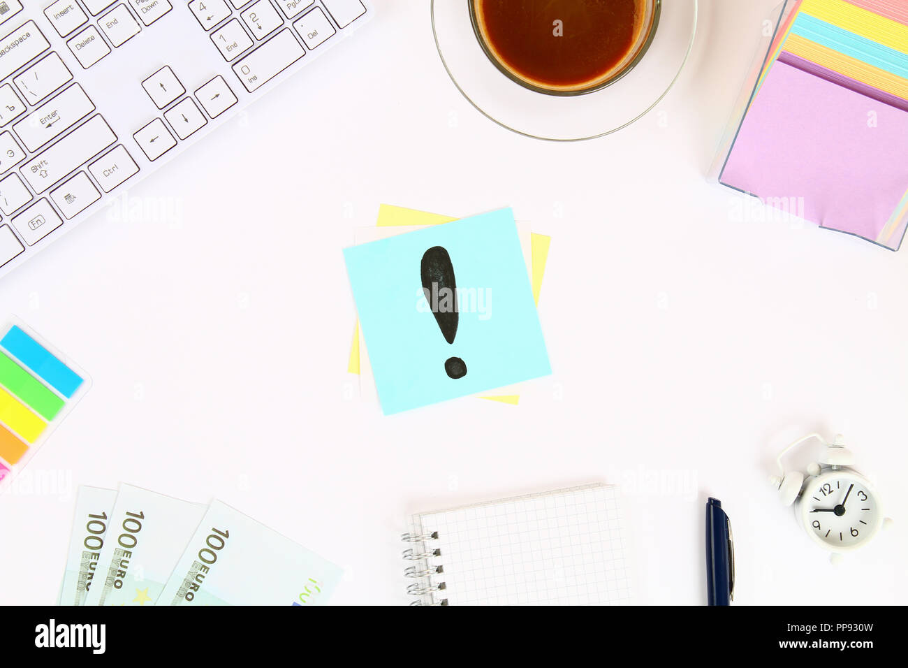 An exclamation point on the sticker is a note on a white desktop next ...