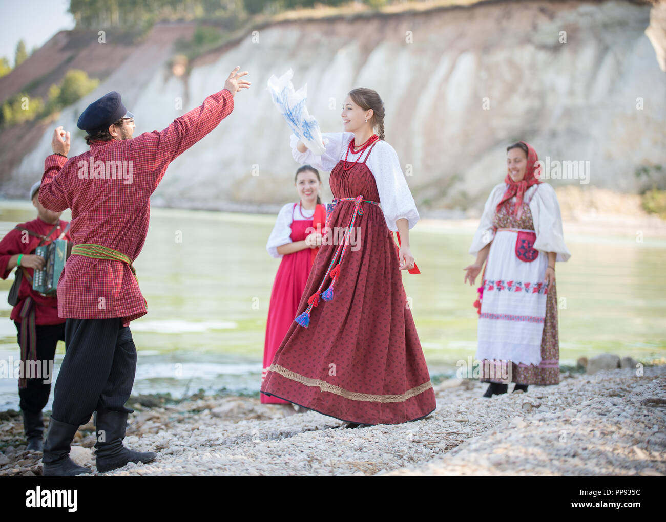 Young people in Russian national costumes dancing folk dances, playing ...