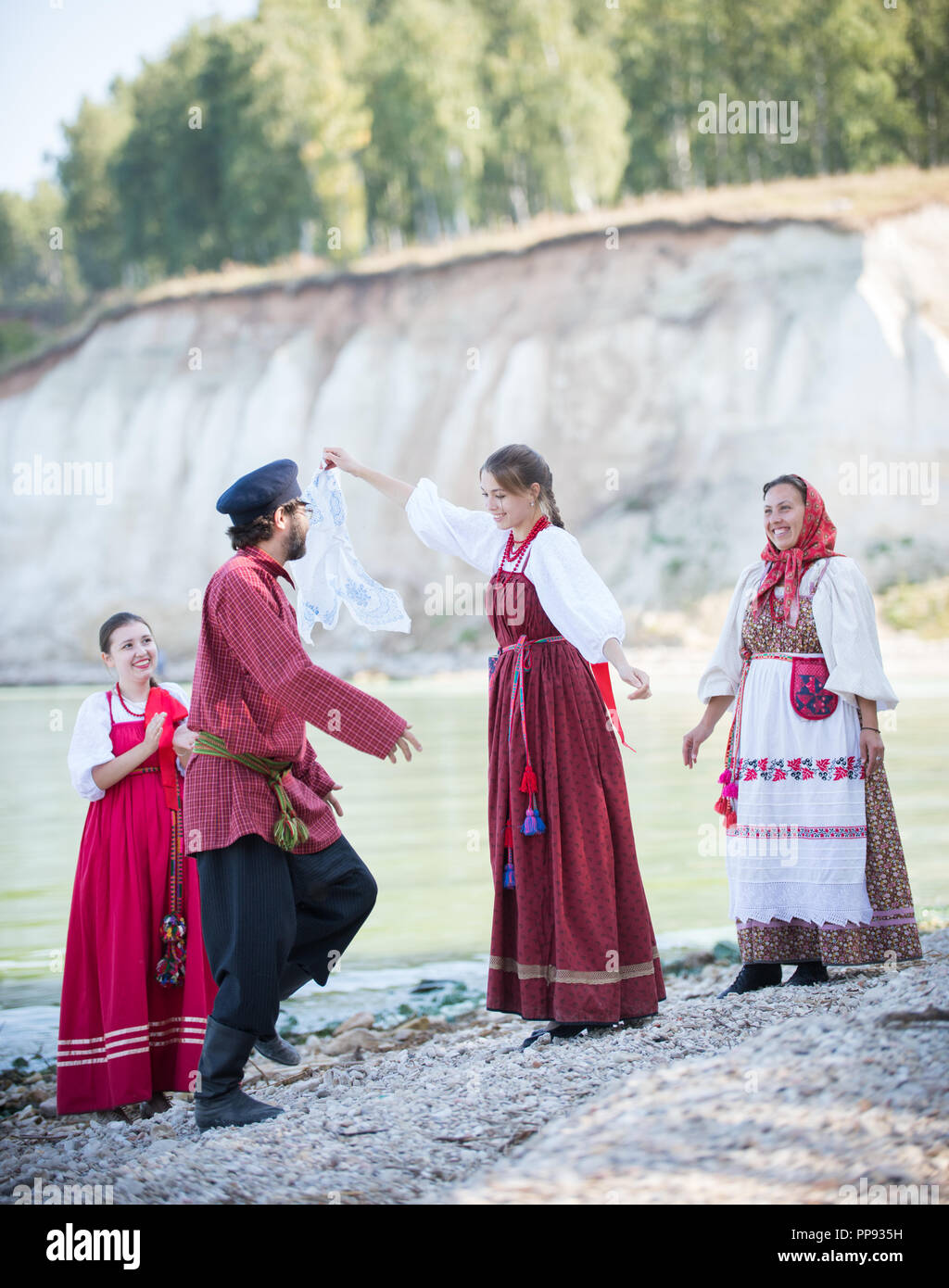 Young people in Russian national costumes dancing folk dances on the ...