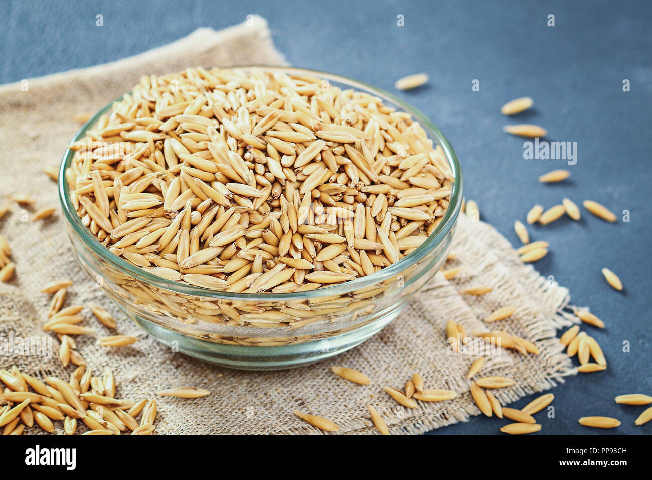 Raw grain of oats in a glass bowl on a gray table Stock Photo - Alamy
