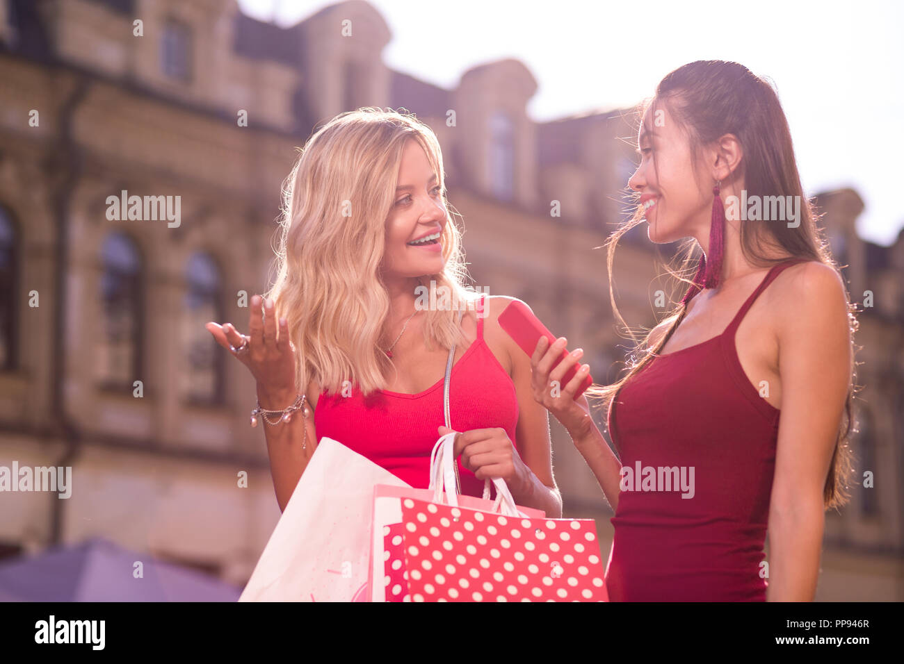 Positive young women talking to each other Stock Photo - Alamy