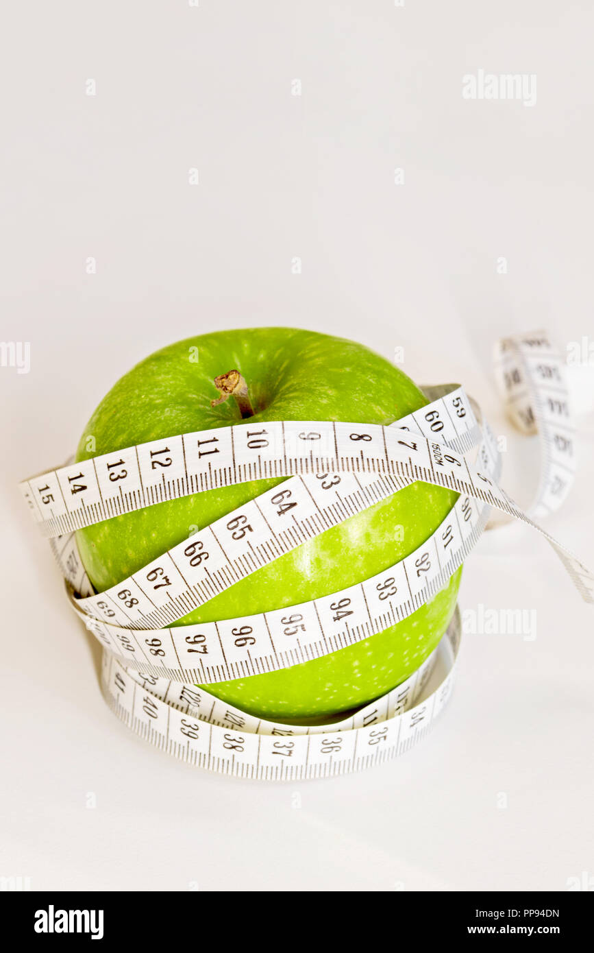 Measuring tape wrapped around a green apple Stock Photo - Alamy