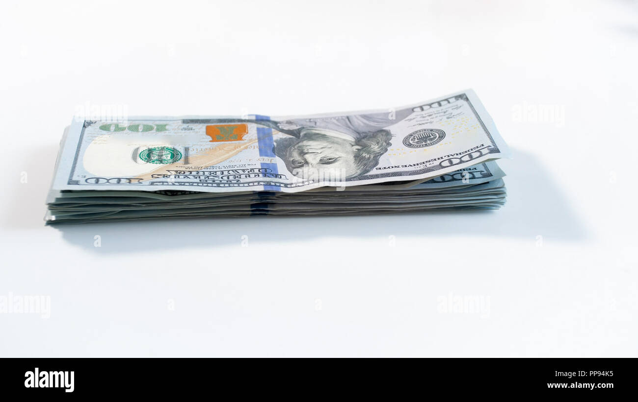 Closeup image of big stack of 100 US dollars lying on white wooden desk ...