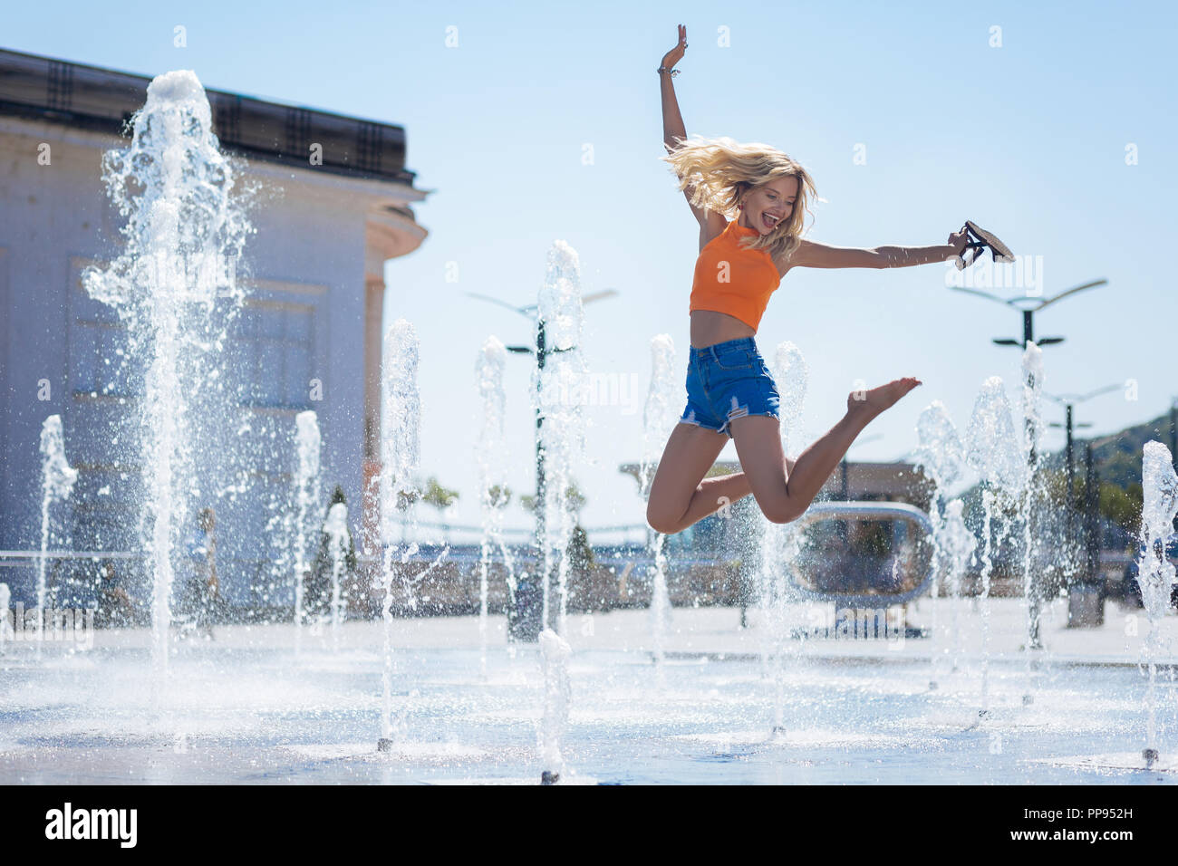 Young woman jumping water fountain hi-res stock photography and images ...