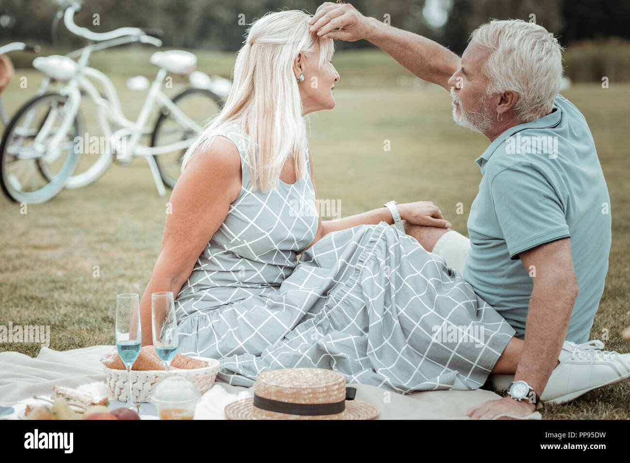 Concentrated mature man touching hair of his wife Stock Photo - Alamy