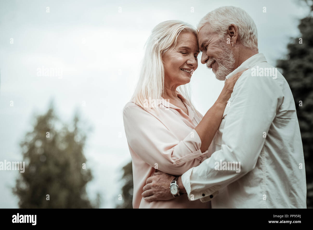 Kind senior people touching with their foreheads Stock Photo - Alamy