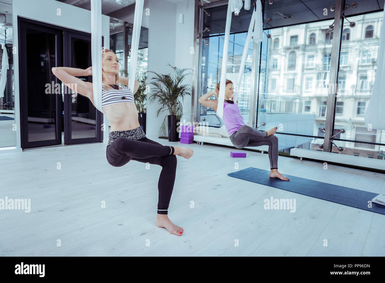 Young two woman finding balance during yoga Stock Photo - Alamy