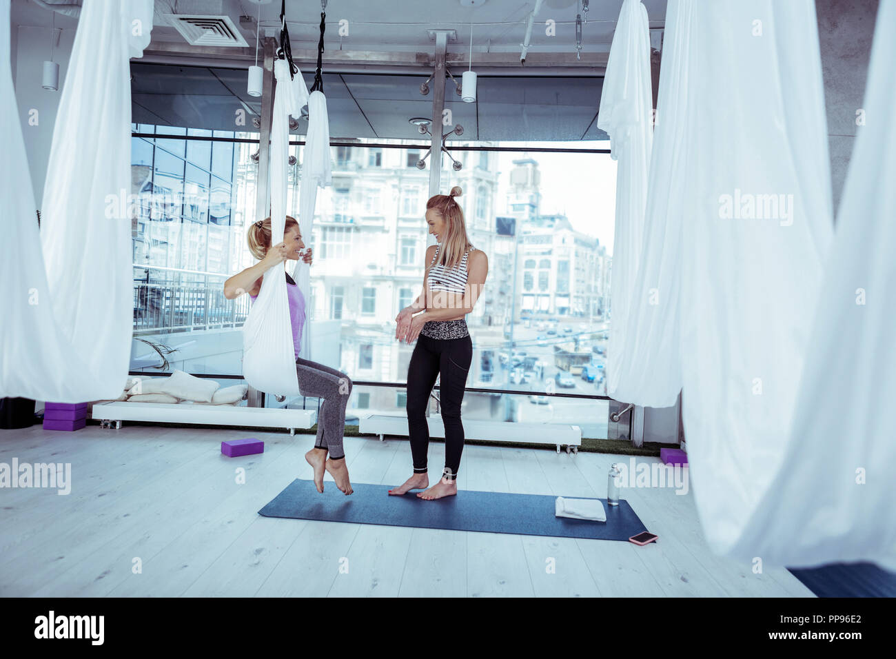 Pleasant female trainer instructing woman before yoga Stock Photo - Alamy
