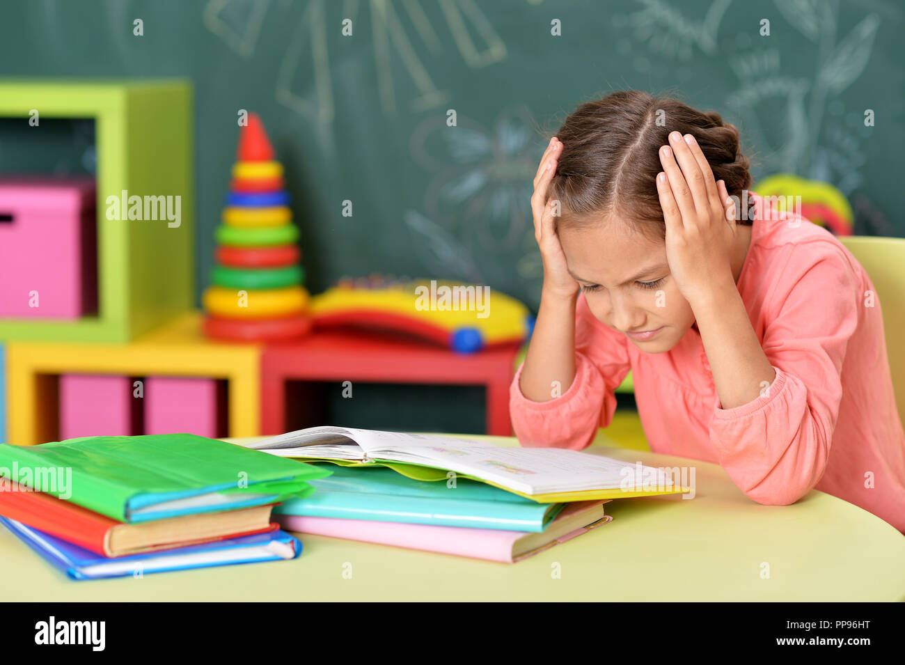 Portait of schoolgirl doing homework in classroom Stock Photo - Alamy