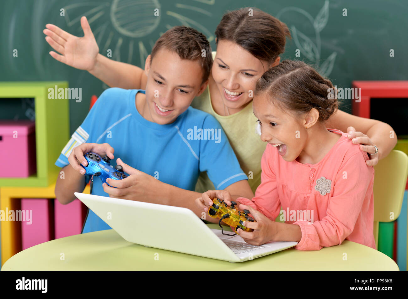 portrait of young mother with children playing computer game wit Stock ...