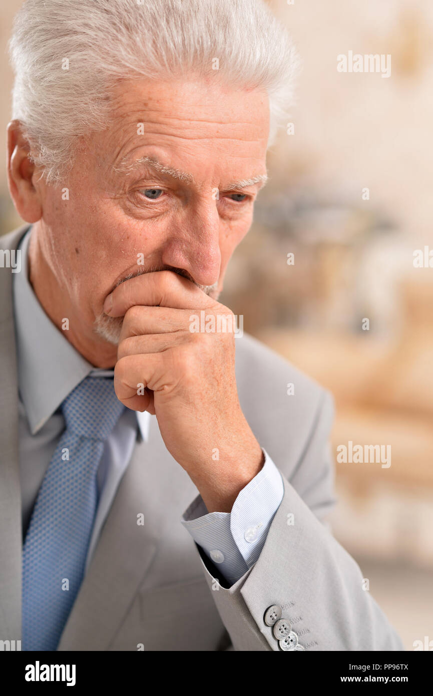 Portrait of elderly business man thinking at home Stock Photo - Alamy