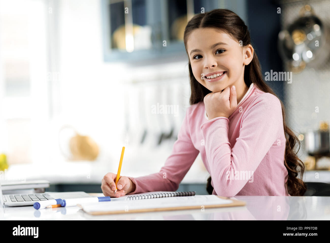Charming positive girl writing answer in notebook Stock Photo - Alamy