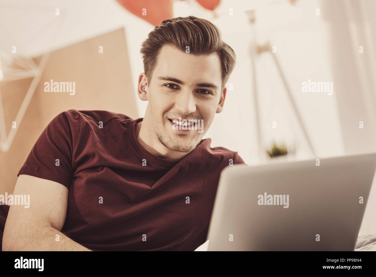 Young smiling man feeling excited while thinking about making surprise ...