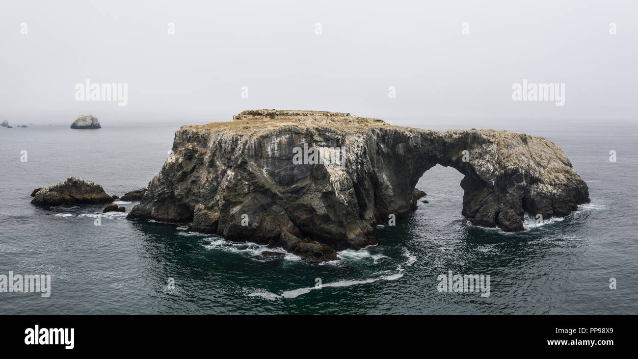 A massive sea stack, formed by the erosive powers of wind and water ...