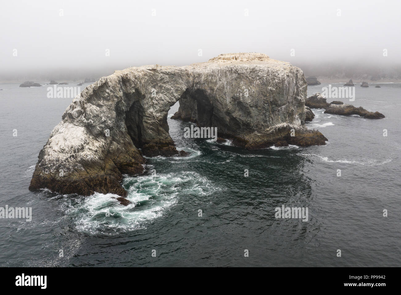 A massive sea stack, formed by the erosive powers of wind and water ...