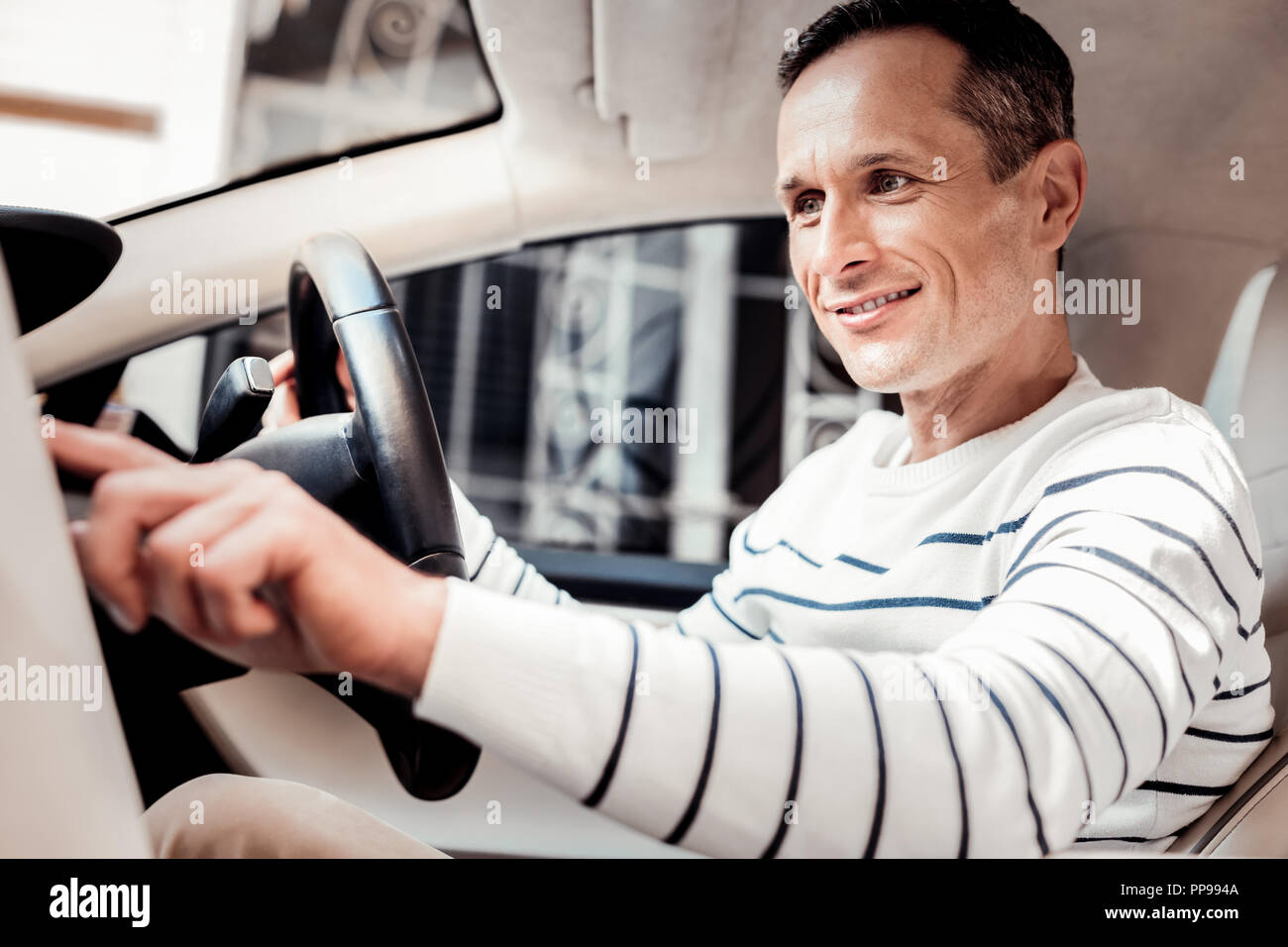 Positive delighted driver preparing the route Stock Photo - Alamy