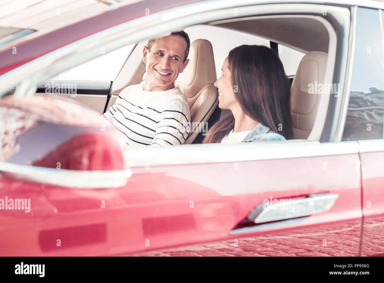 Handsome driver looking at his passenger Stock Photo - Alamy