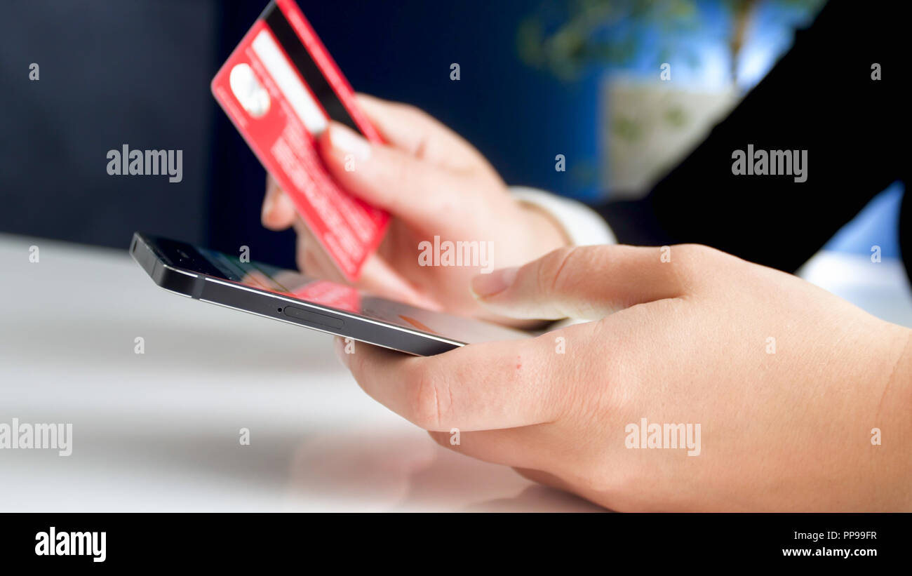 Closeup image of young woman making online purchases with credit card ...