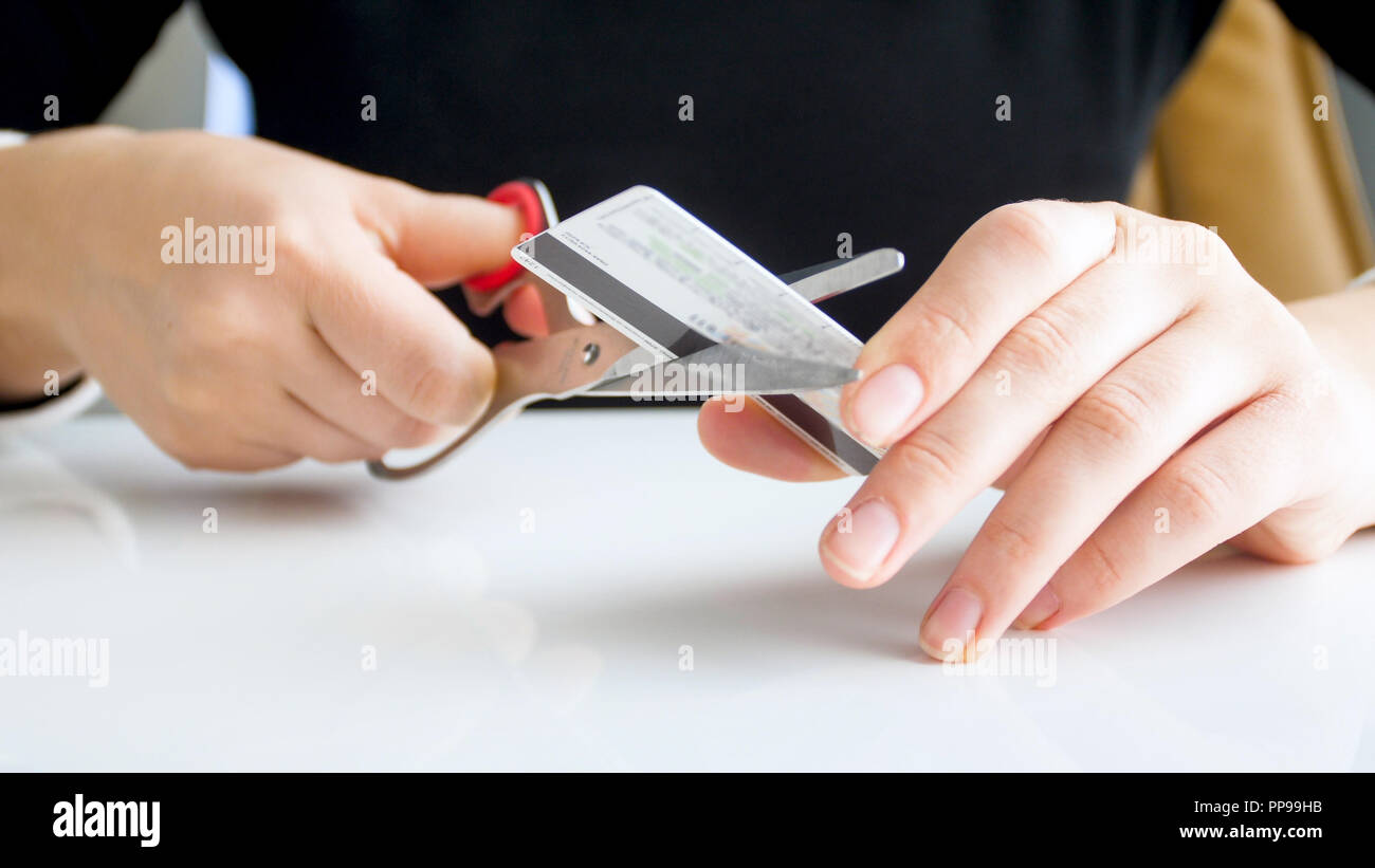 Closeup image of bank female worker cutting expired credti card with ...
