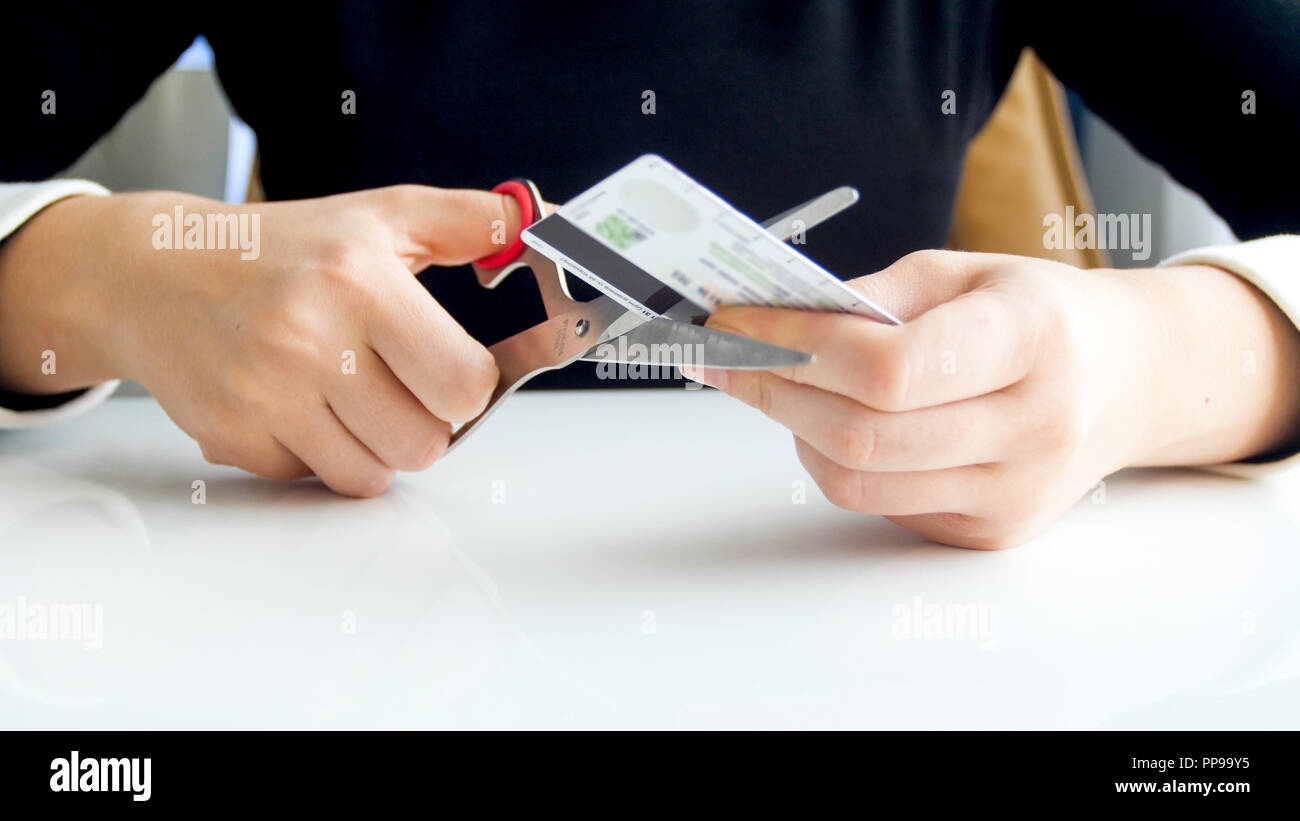 Closeup photo of bank worker cutting expired credit card with scissosrs ...
