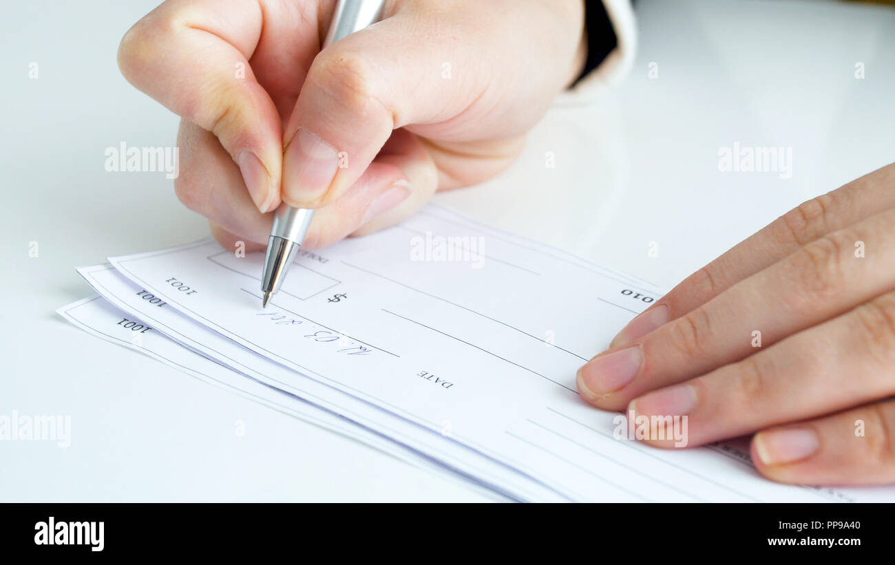 Woman signing cheque hi-res stock photography and images - Alamy