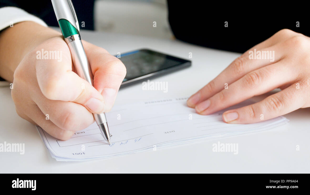 Closeup image of businesswoman putting signature on banking payment ...
