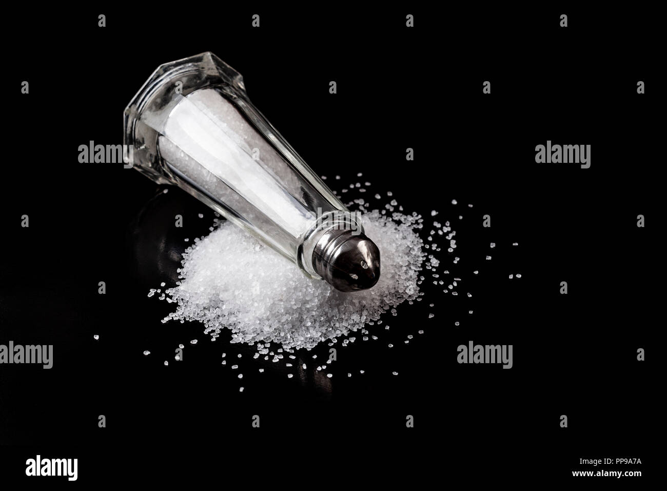 Glass Salt Shaker on Pile of White Sea Salt Crystals Pile on Black ...
