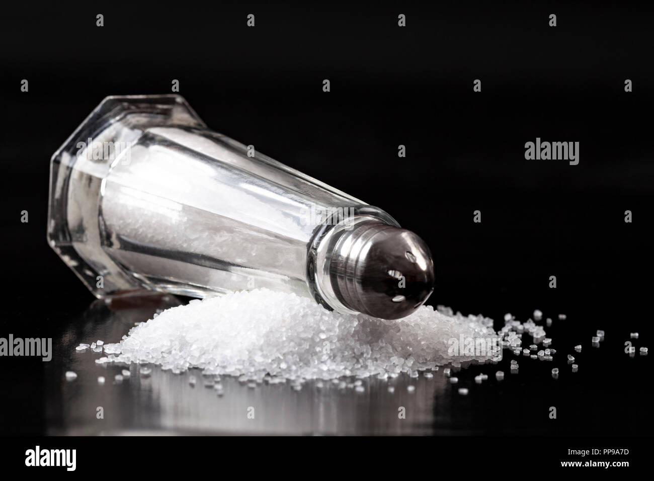 Salt Shaker on White Sea Salt Pile on Black Background Stock Photo - Alamy