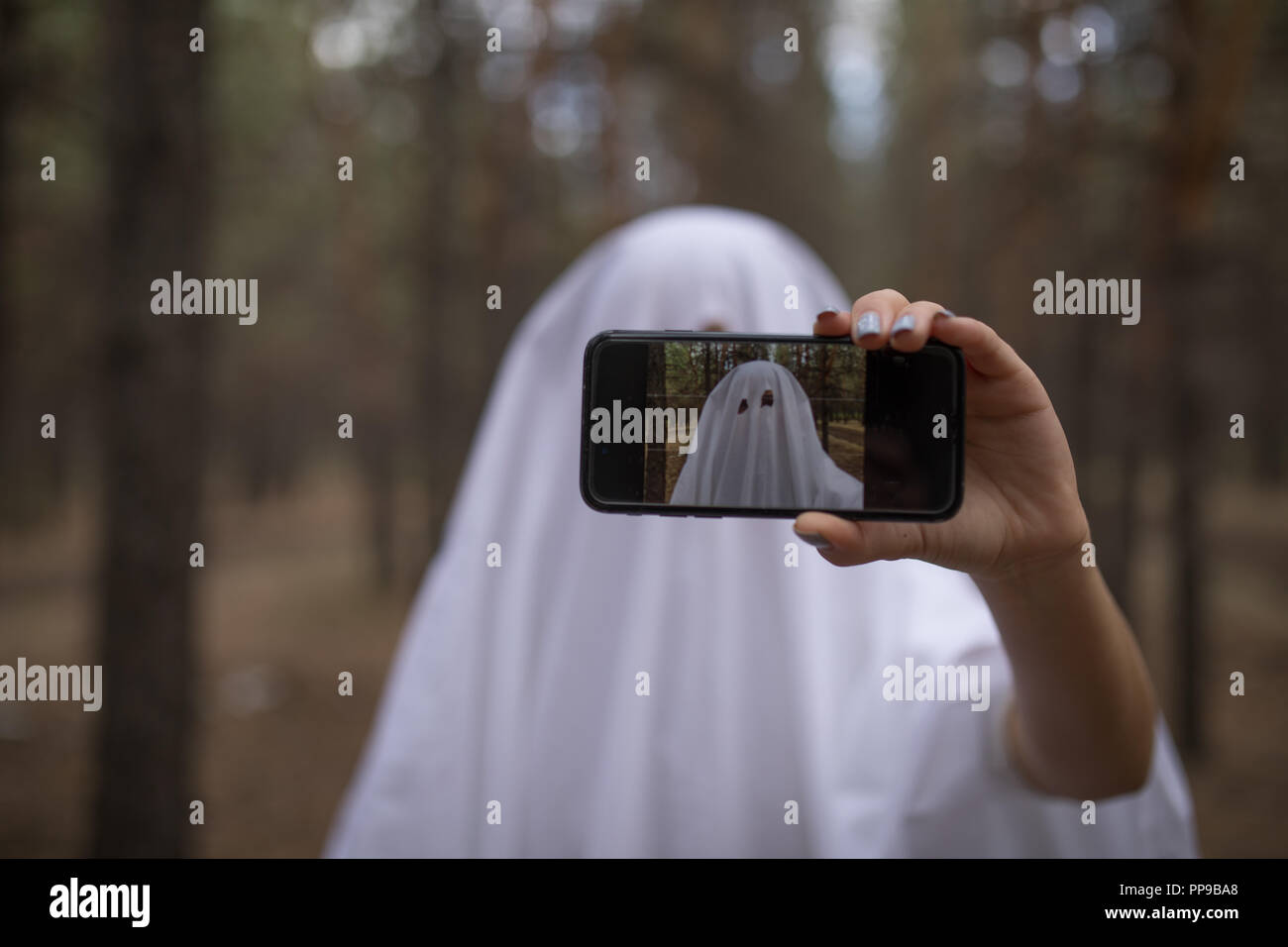 Woman in halloween ghost costume make selfie in the forest Stock Photo ...