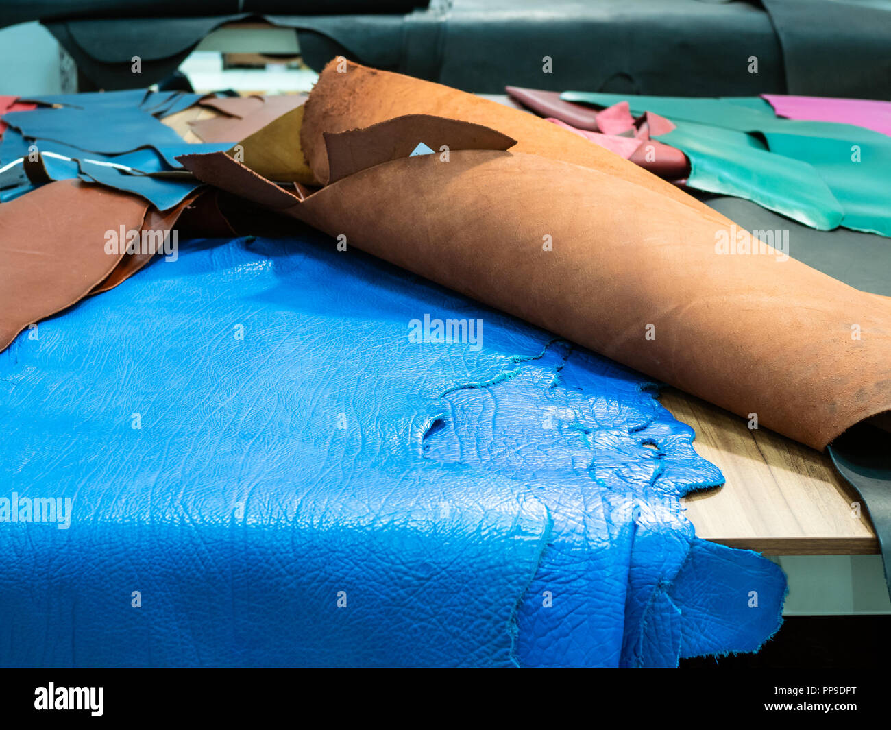 blue colored cowhides on table in leather workshop Stock Photo - Alamy