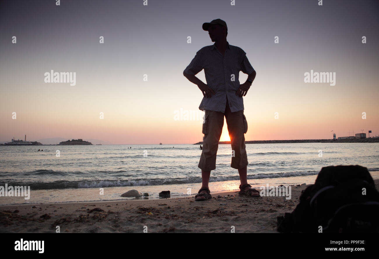 Tourist on a beach against sunset Stock Photo - Alamy