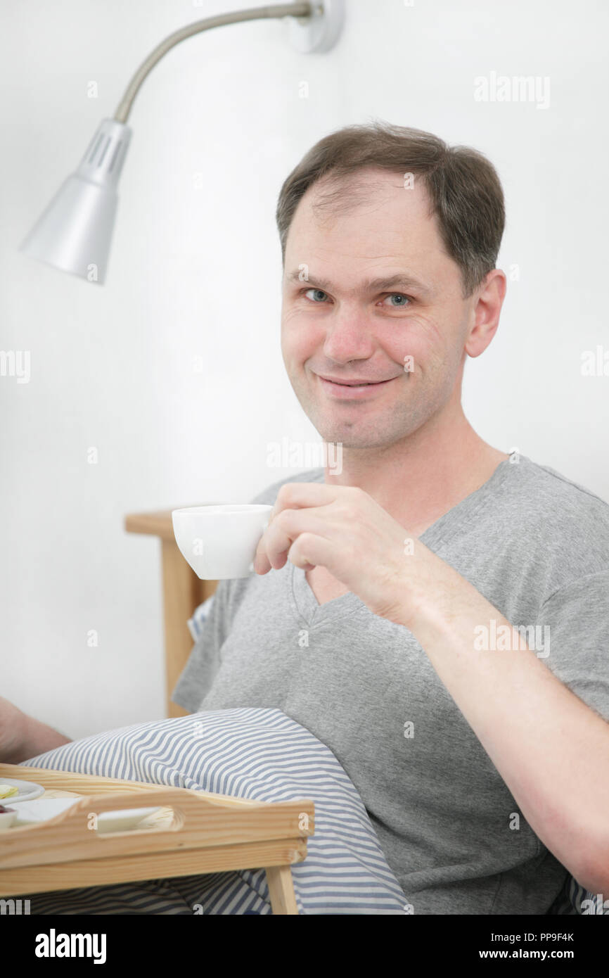 Man eating breakfast on the bed Stock Photo - Alamy