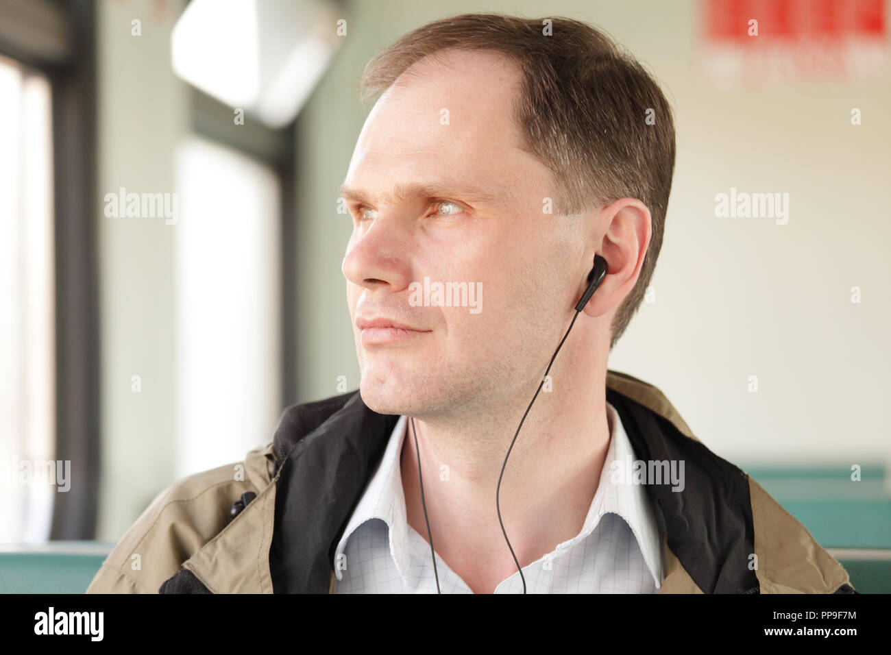 Man listening music with headphones in the train Stock Photo - Alamy