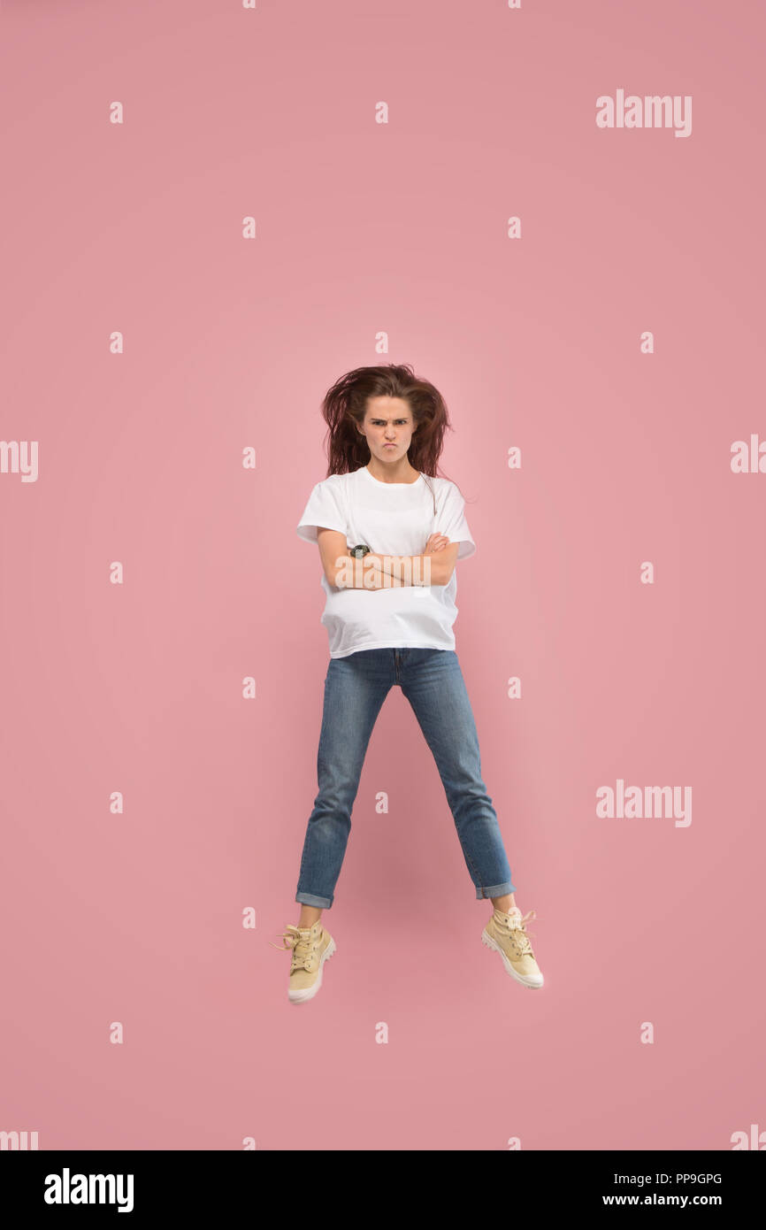 Freedom in moving. Mid-air shot of pretty serious angry young woman ...