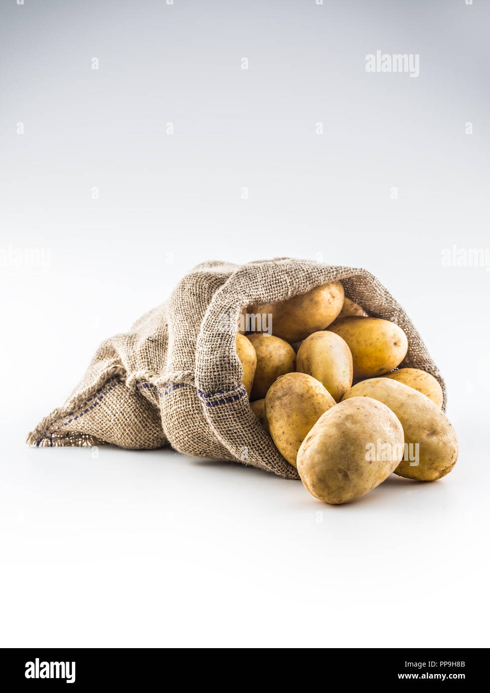 New potatoes in burlap sack isolated on white background Stock Photo ...