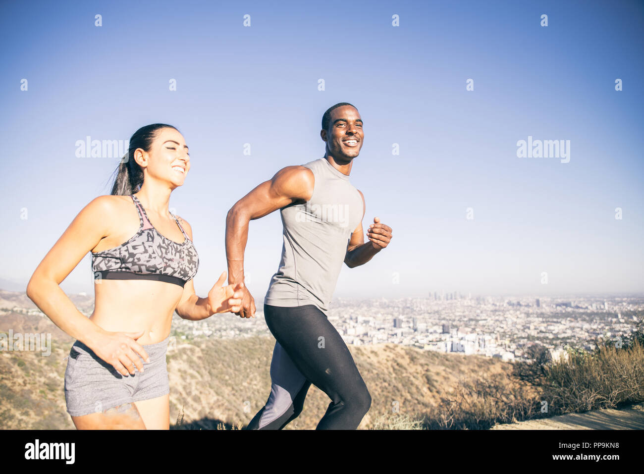 Multi-ethnic couple training in a canyon - Sportive boyfriend and ...