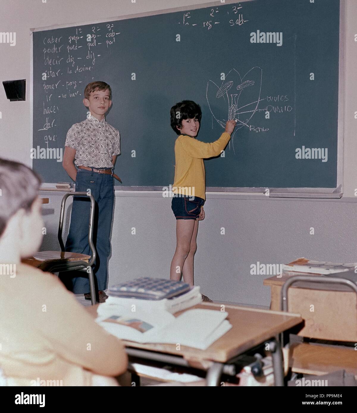 STUDENTS IN A CLASSROOM WRITING ON THE BLACKBOARD Stock Photo - Alamy