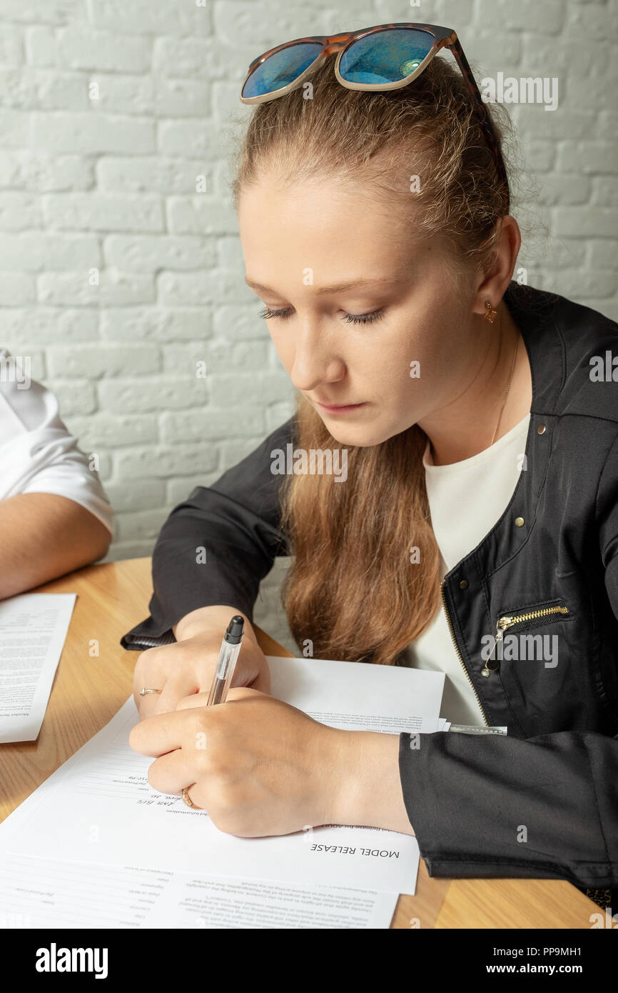 A girl writes a document on a piece of paper Stock Photo - Alamy