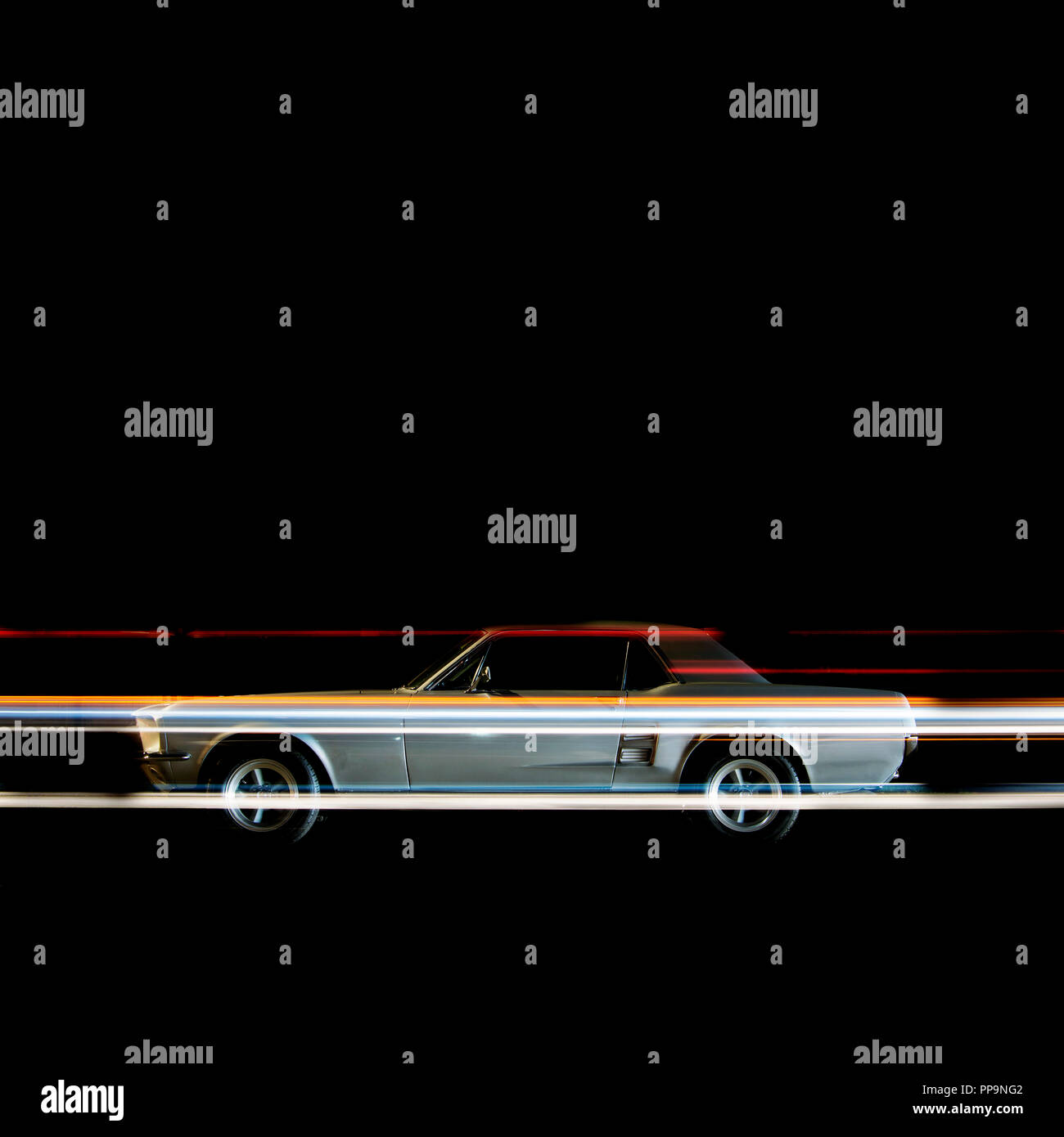 A view of a vintage classic American muscle sports car and light trails ...