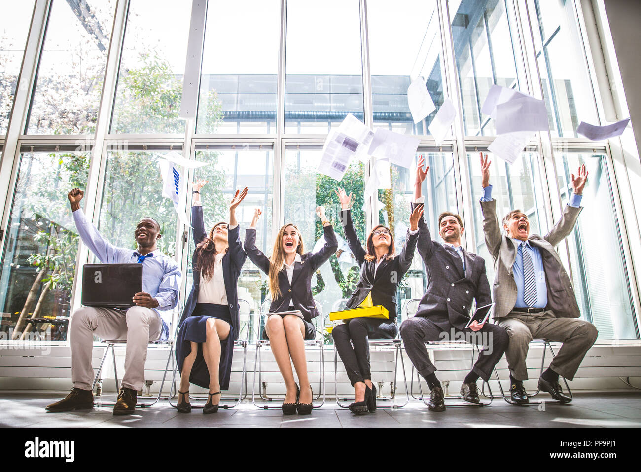 Business team exulting - Happy cheerful businessmen rising arms and ...