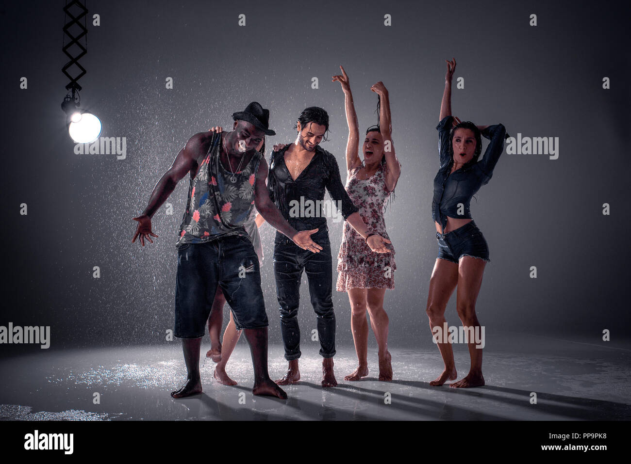 Group of friends dancing under the rain - Multiethnic people having ...